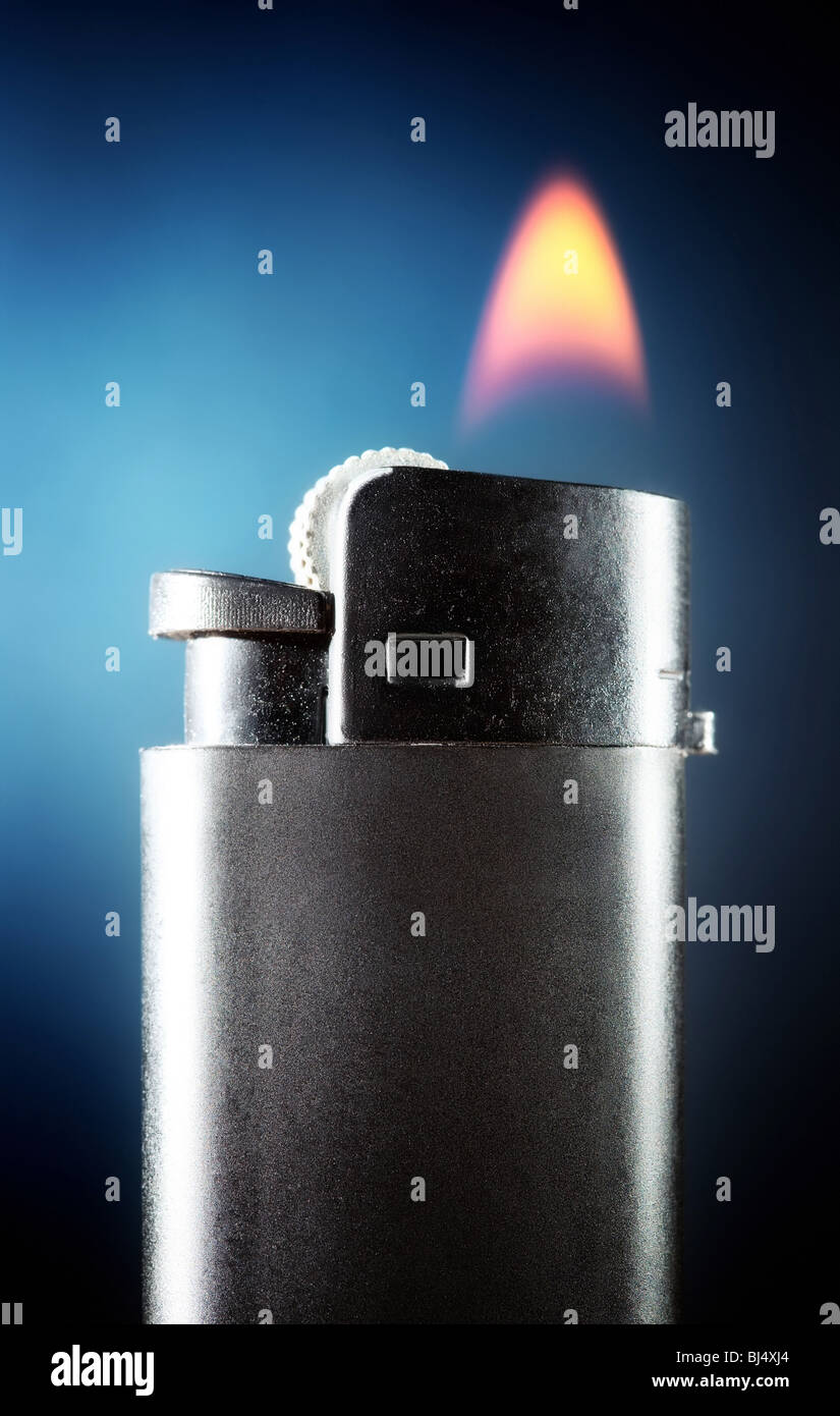 Lighter with burning flame. On blue background Stock Photo - Alamy