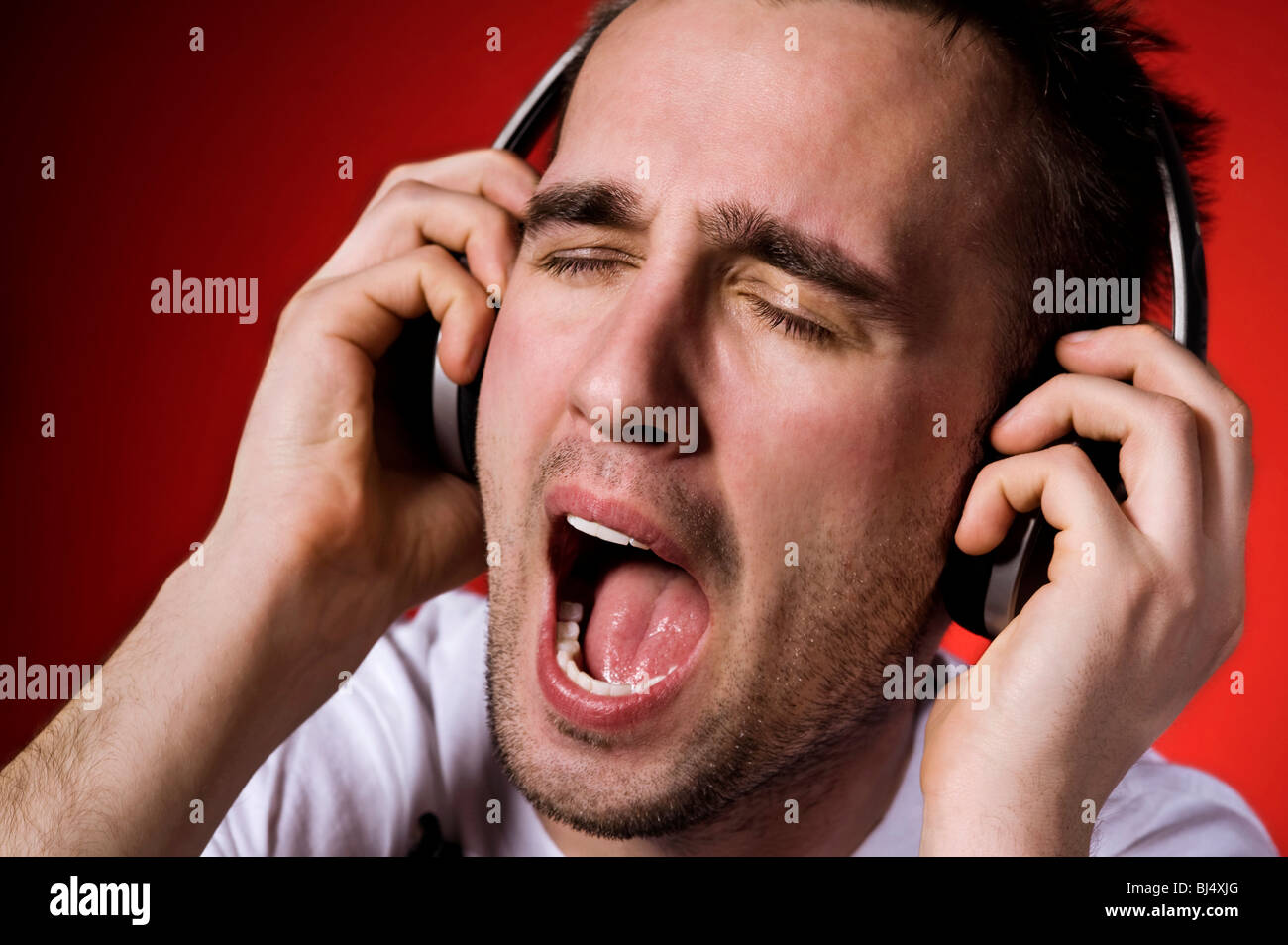 singing young man wearing headphones Stock Photo - Alamy
