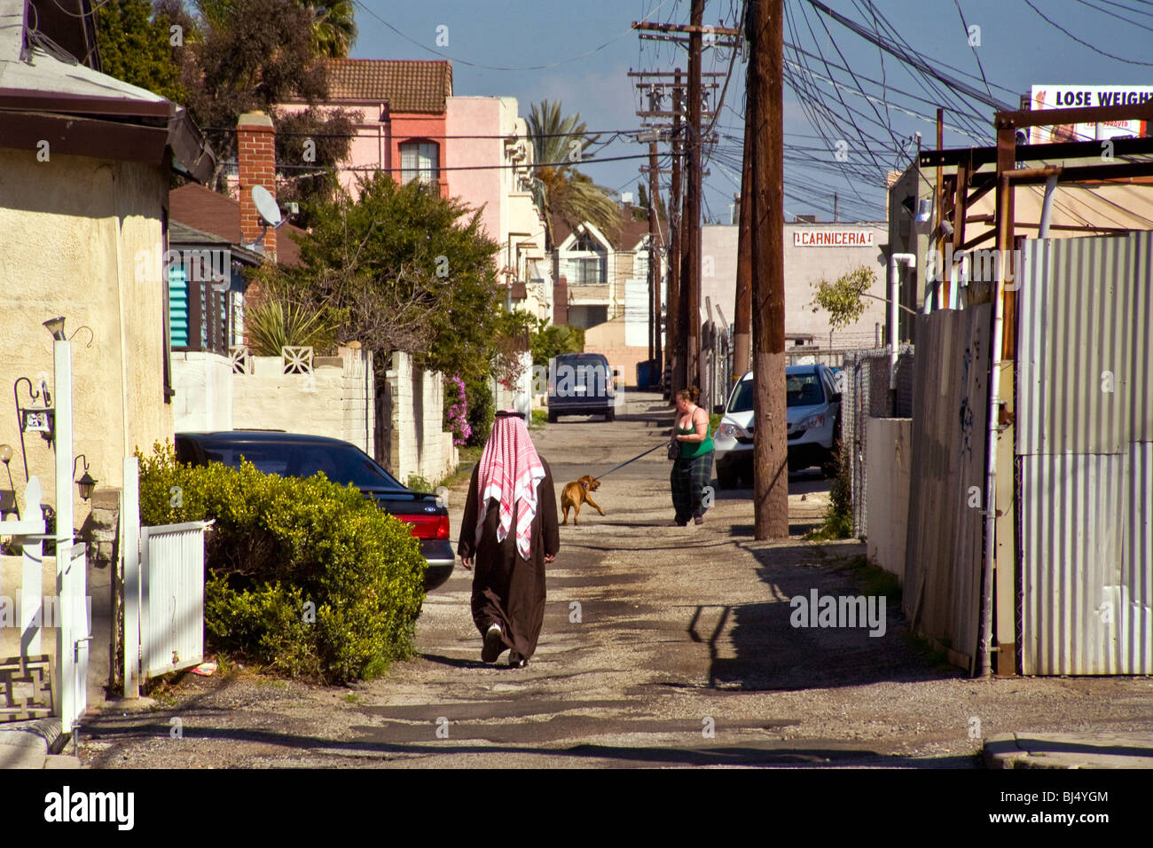 A traditionally dressed Muslim male strolls down an alley in Los ...