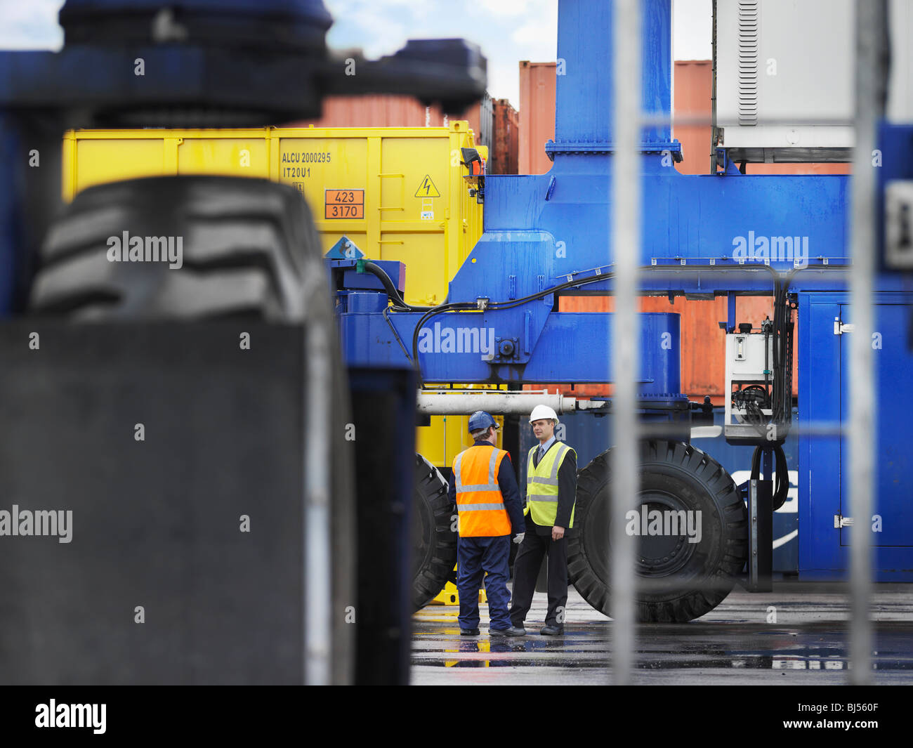 Port Workers With Heavy Machinery Stock Photo - Alamy