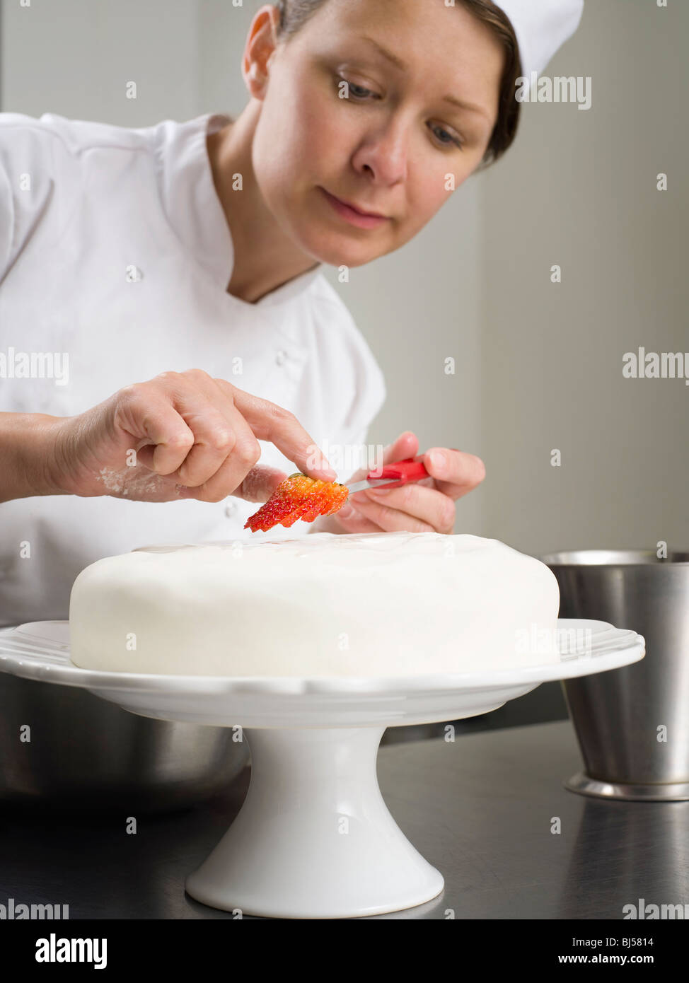 A female chef cake decorating Stock Photo - Alamy