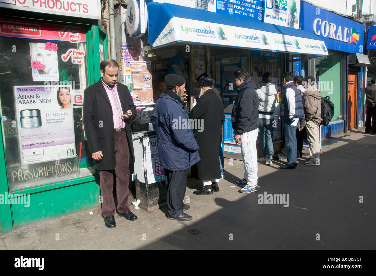 UK MUSLIM AND INDIAN MEN AT A MOBILE PHONE SHOP IN WHITECHAPEL MARKET ...