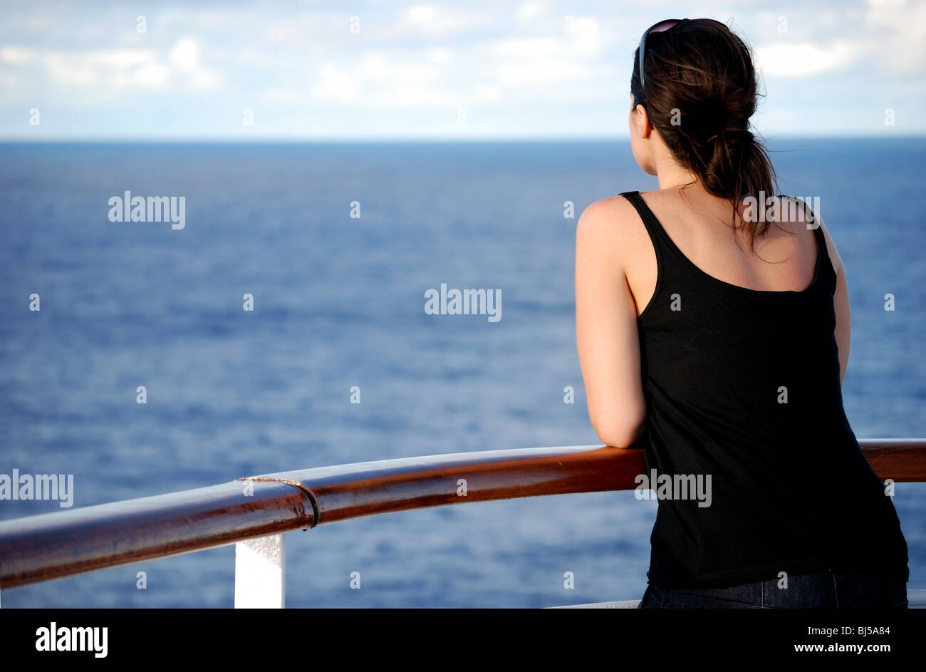Beautiful young woman looking out to sea on board a cruise ship Stock ...