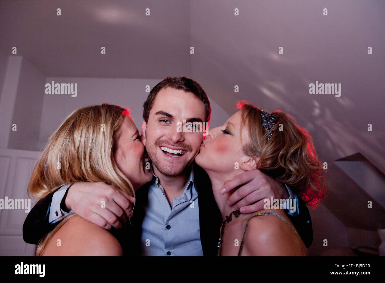 man being kissed by two women Stock Photo - Alamy