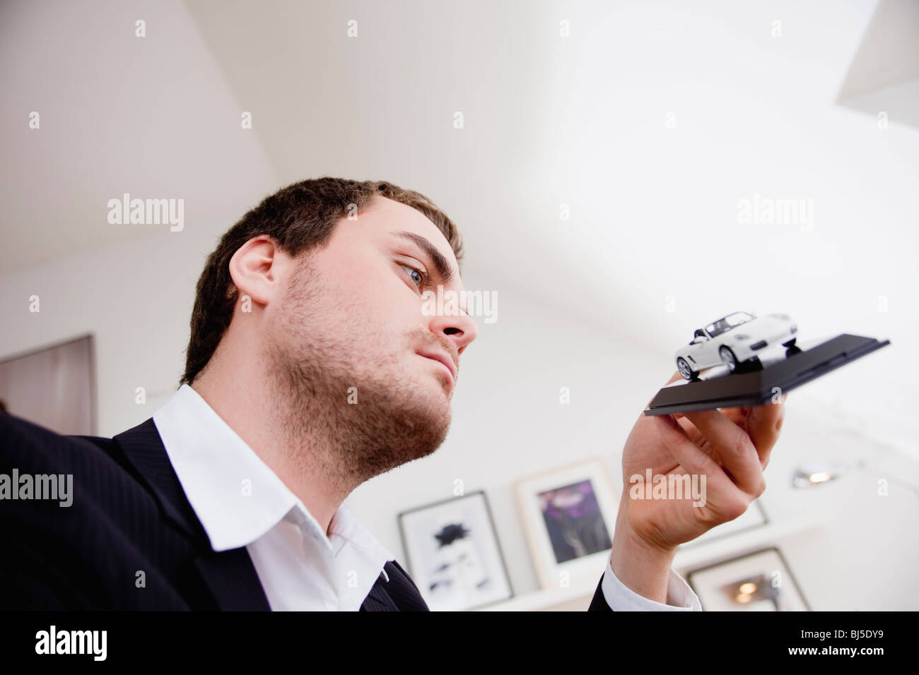 man inspecting toy car model Stock Photo - Alamy