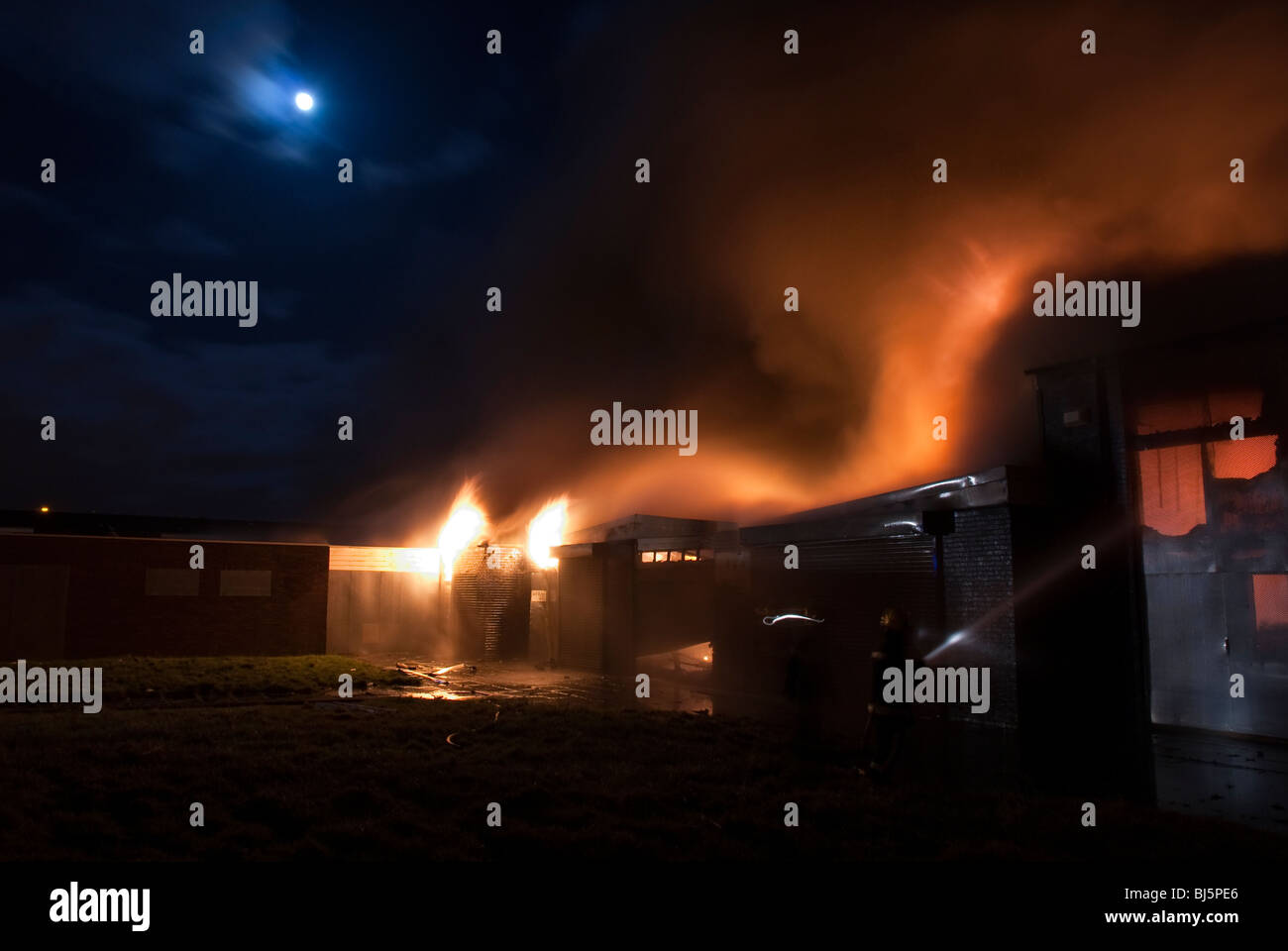School on fire at night with flames, smoke and moon in background Stock ...