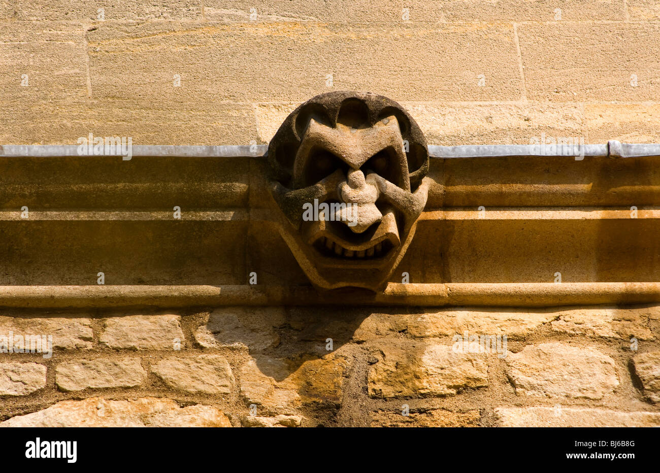 a comic stylized gargoyle on a college wall in Oxford UK (New College ...