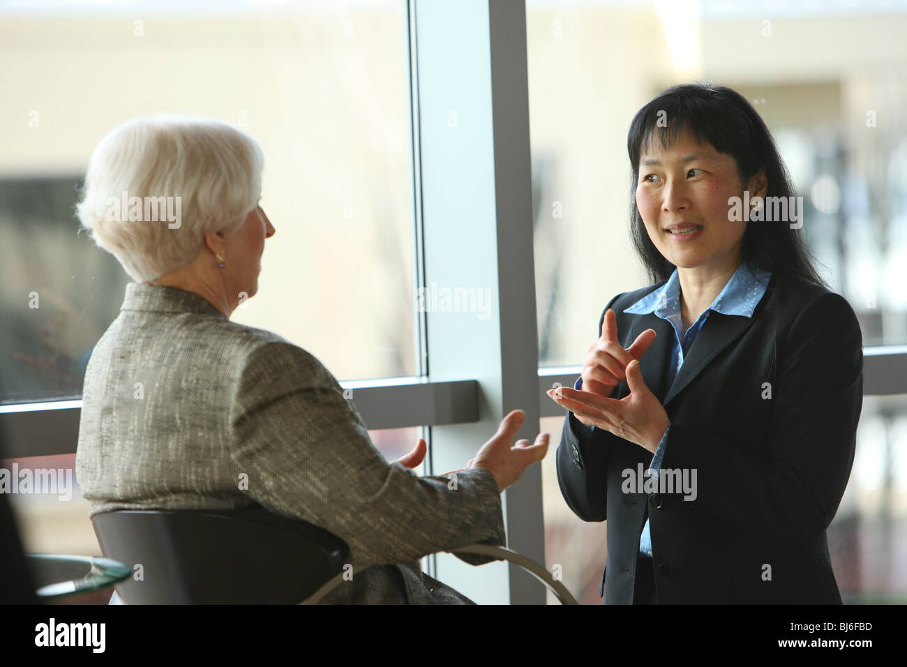 Two business women talking Stock Photo - Alamy