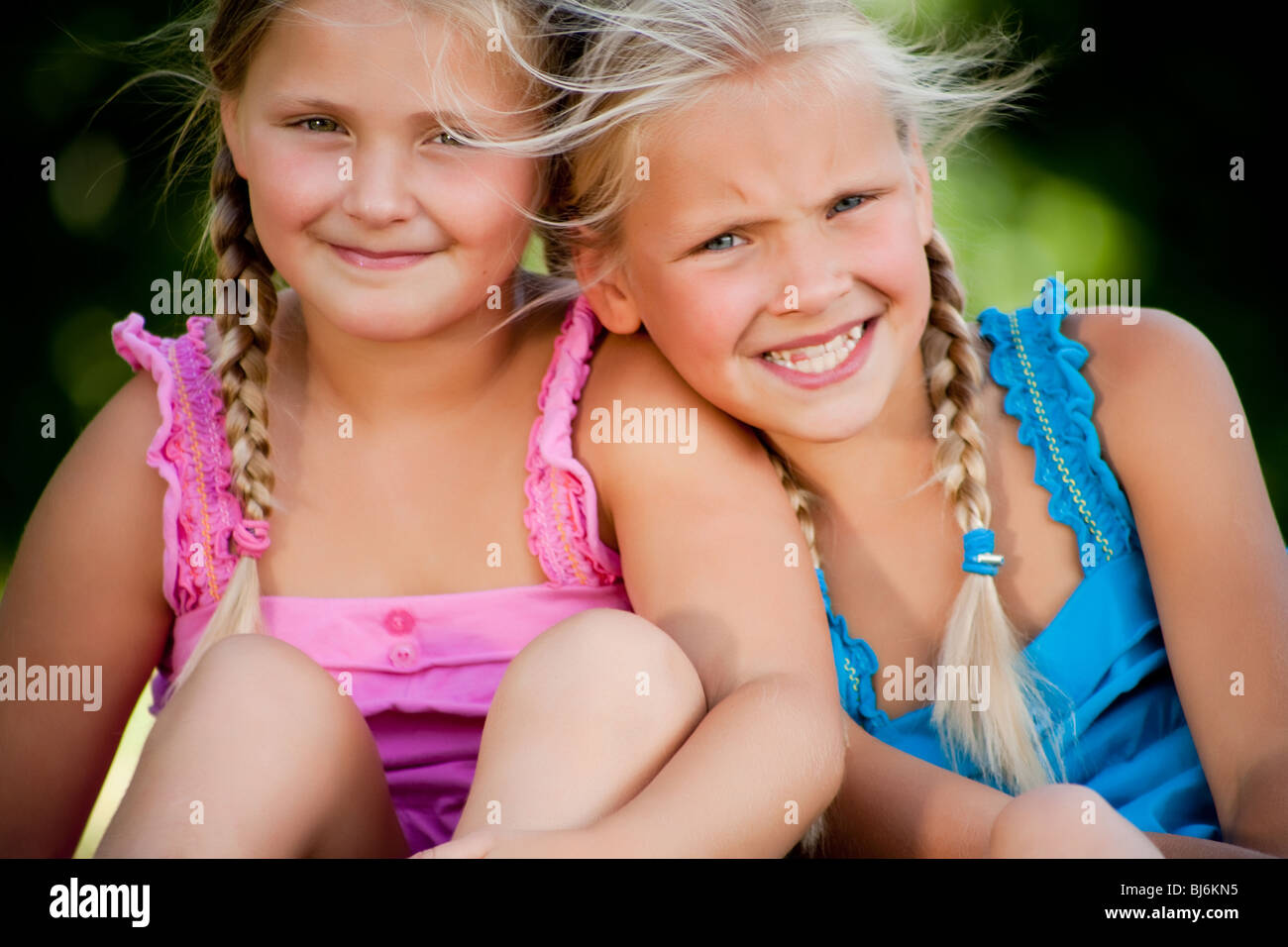 Two little girls in fresh colors in the park Stock Photo - Alamy
