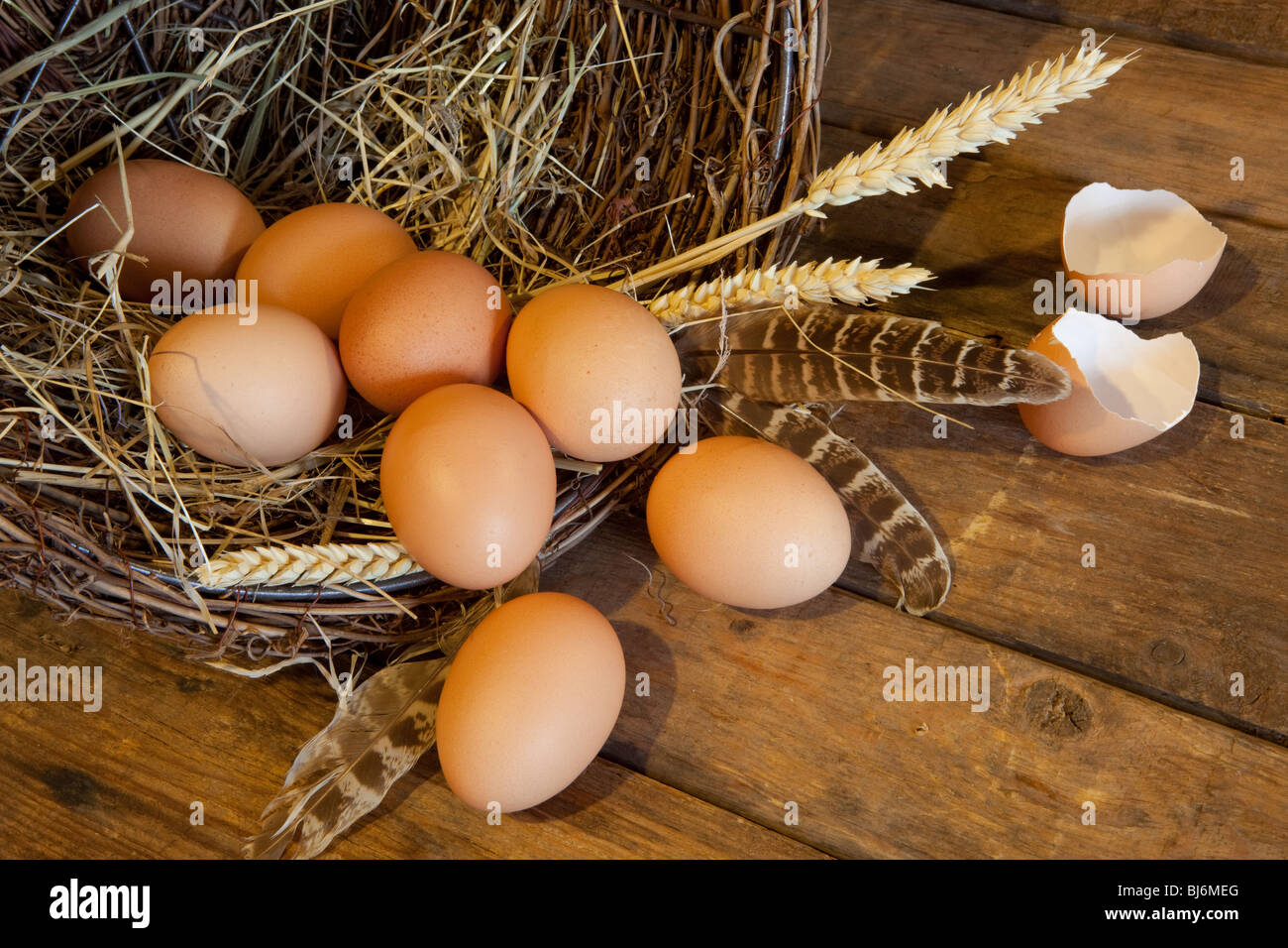 Rustic basket filled with eggs, feathers, wheat and hay Stock Photo - Alamy