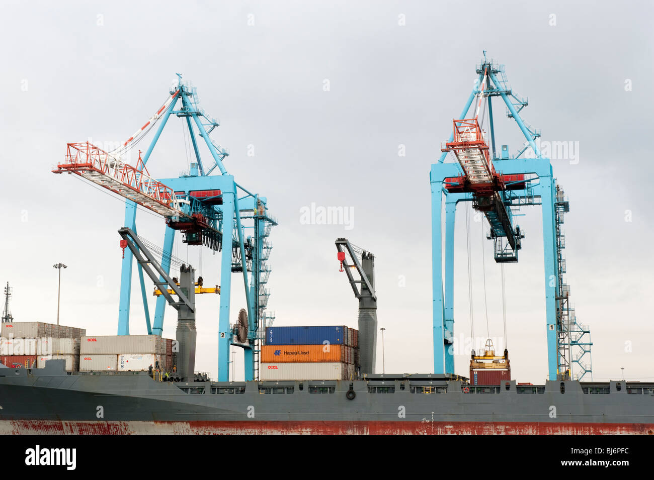Cranes unloading ships hold Stock Photo - Alamy