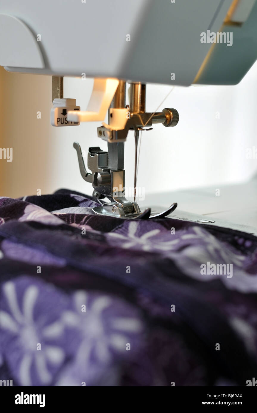 Sewing machine sewing purple textile Stock Photo - Alamy