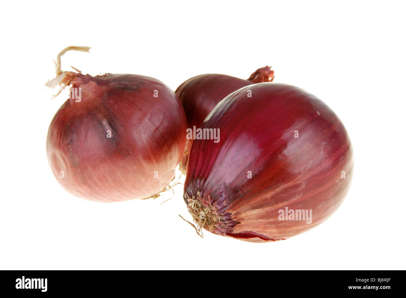 Three red onion on white background close-up Stock Photo - Alamy