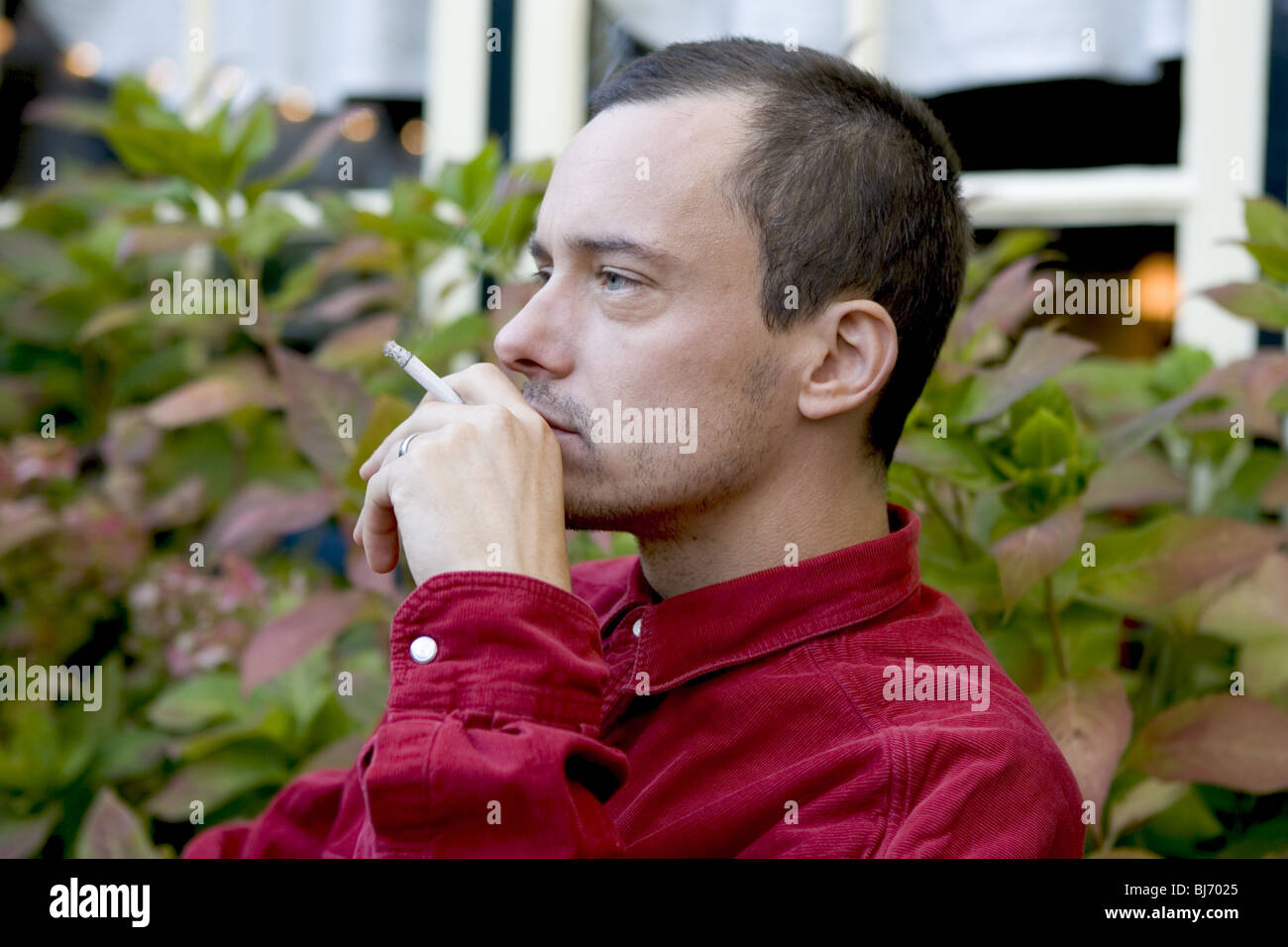 Profile middle age man smoking a cigarette outside Stock Photo - Alamy