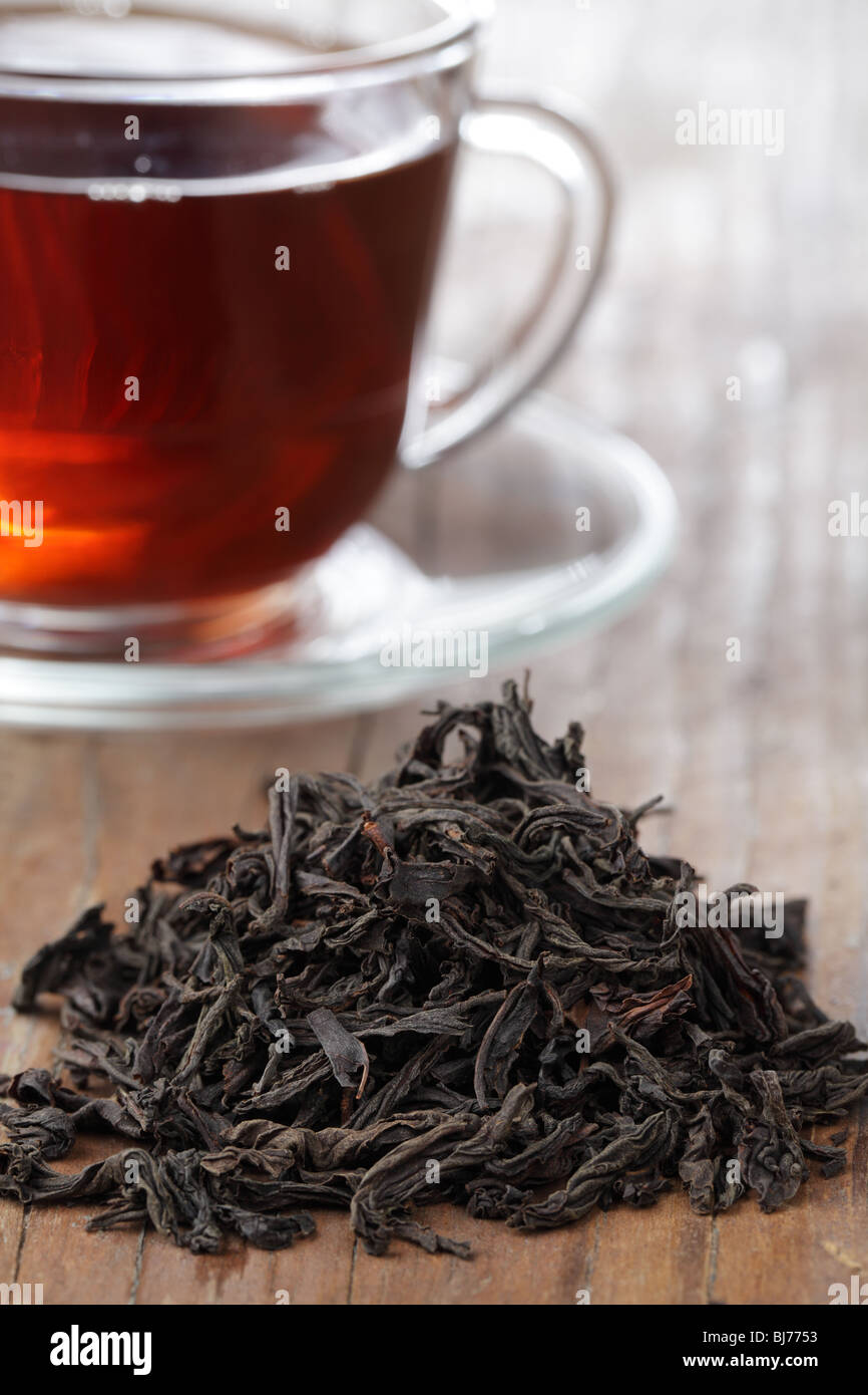 Heap of dried tea leaves and a cup of black tea Stock Photo - Alamy
