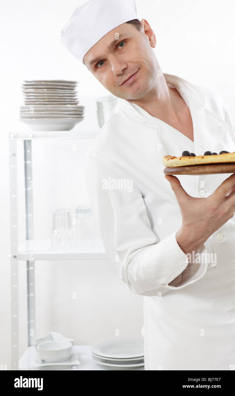 Chef carrying pizza out of kitchen Stock Photo - Alamy
