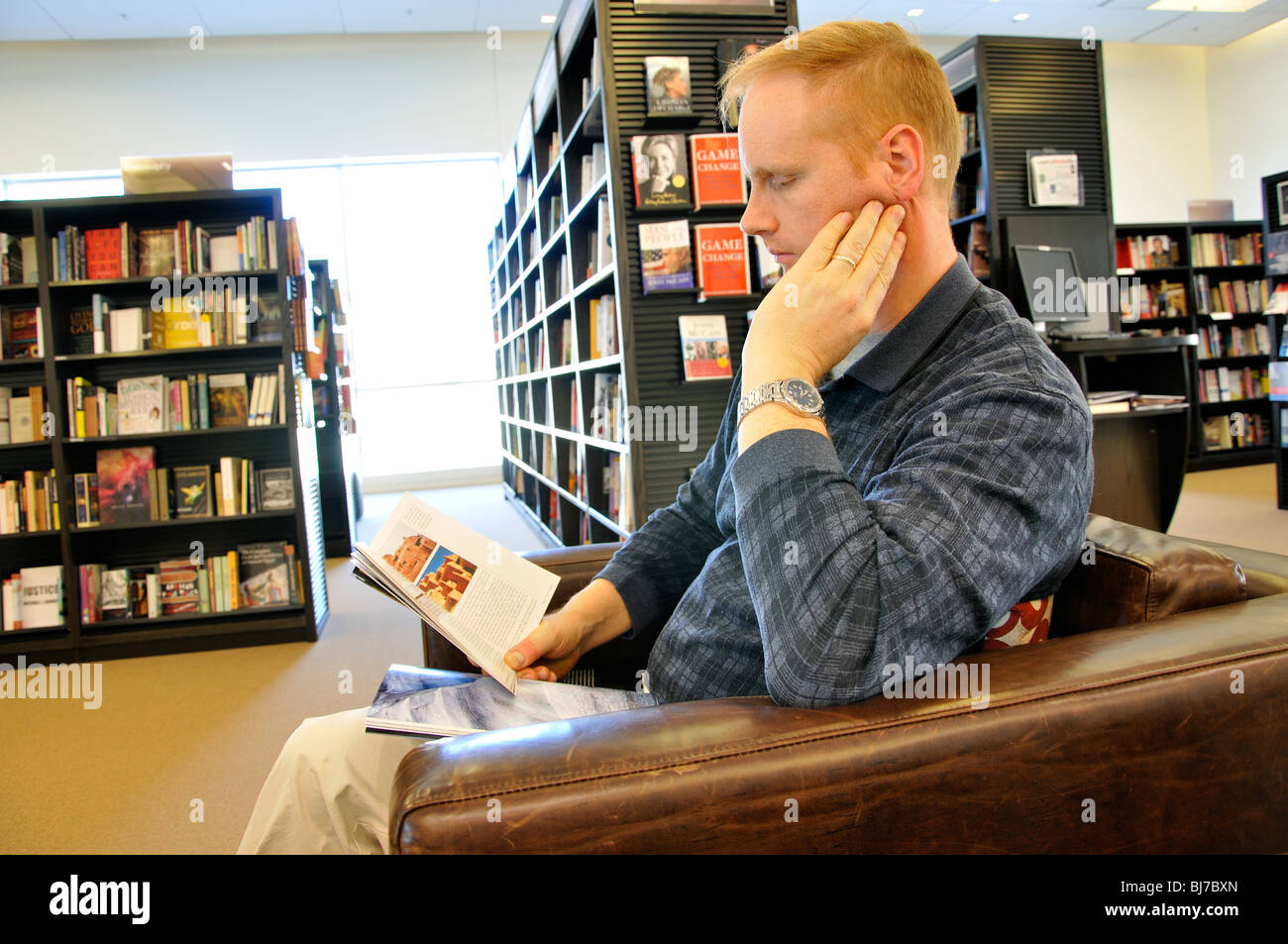 Man reading book in bookstore Stock Photo - Alamy