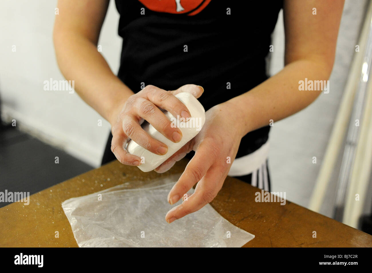 Female weightlifter rubs chalk on to her hands to help with grip Stock ...