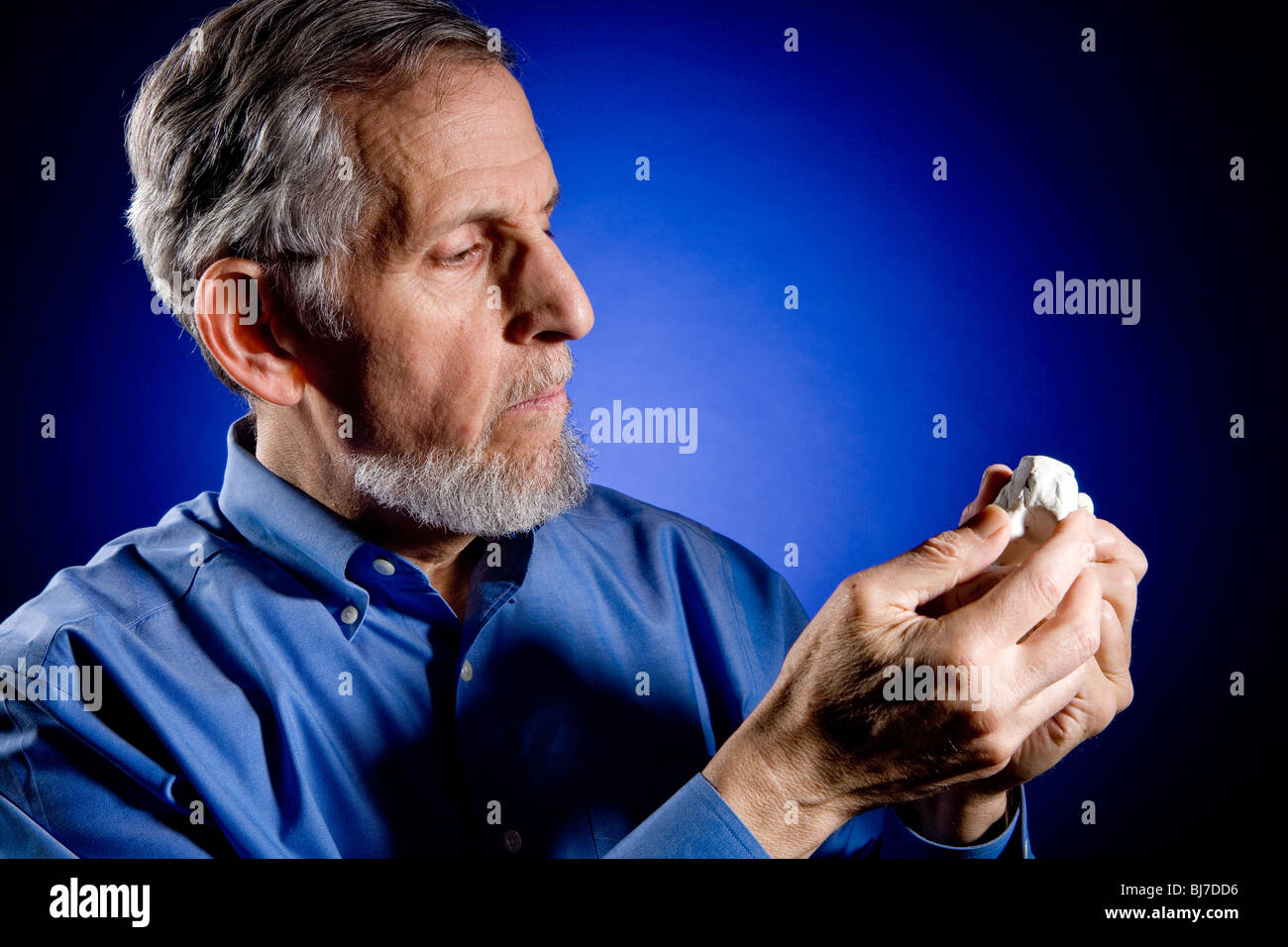 Sculptor Inspecting Clay on Blue Background Stock Photo - Alamy