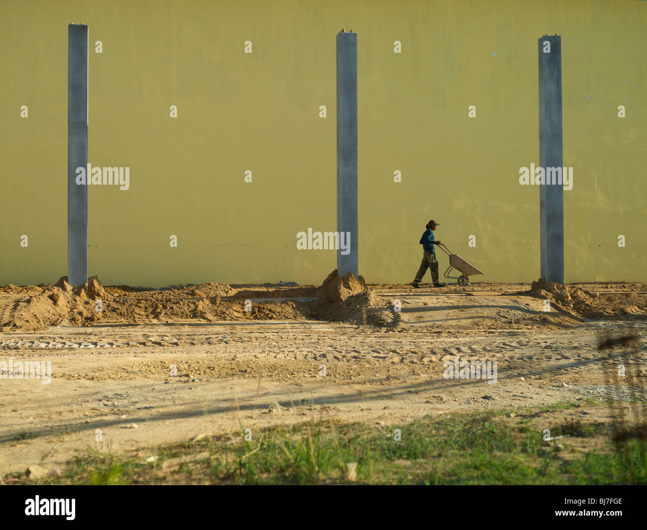 Man at work with a wheel barrow on a building site in Thailand Stock ...