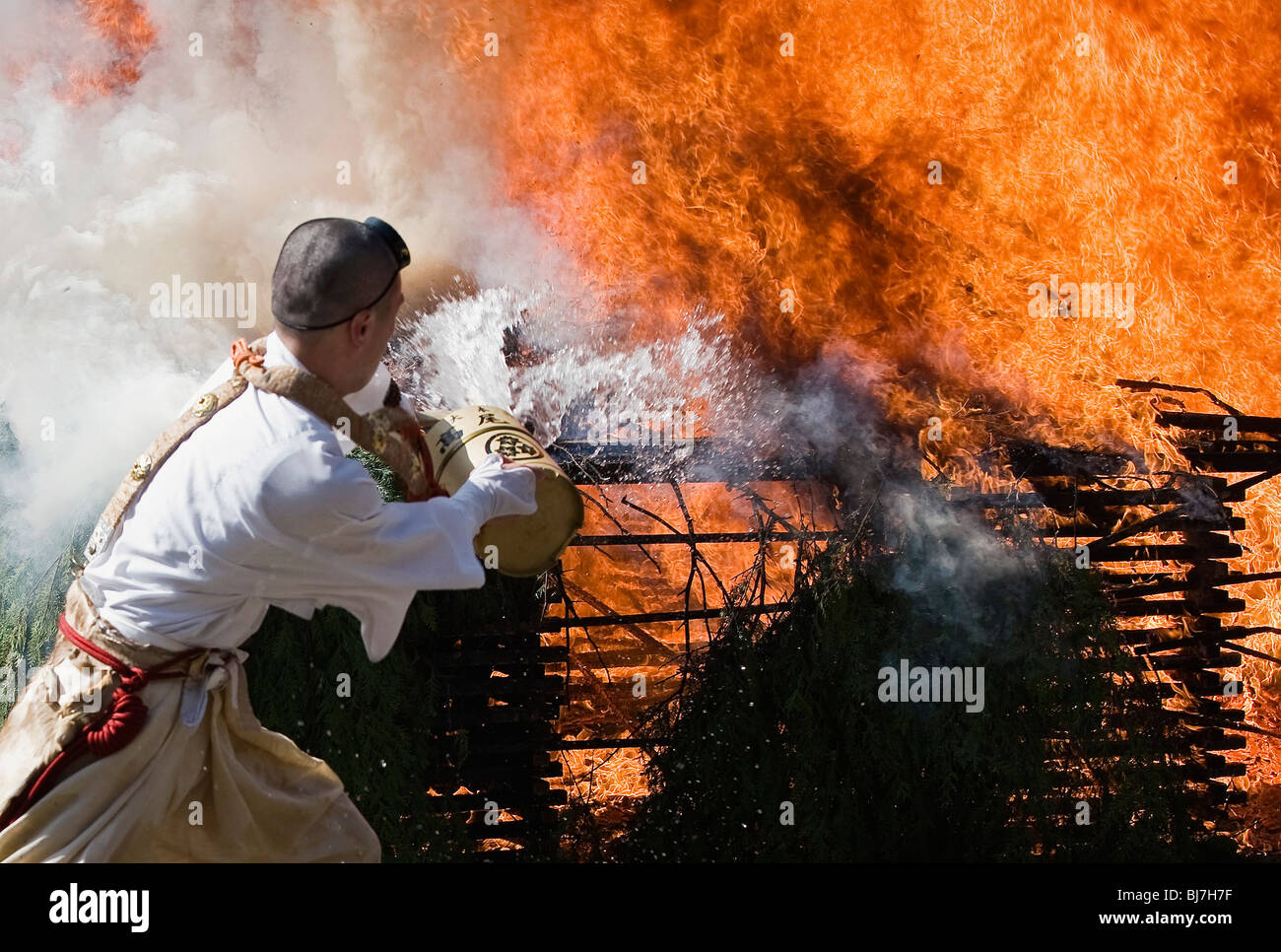 A Buddhist priest douses the flames of a fire used in a purification ...