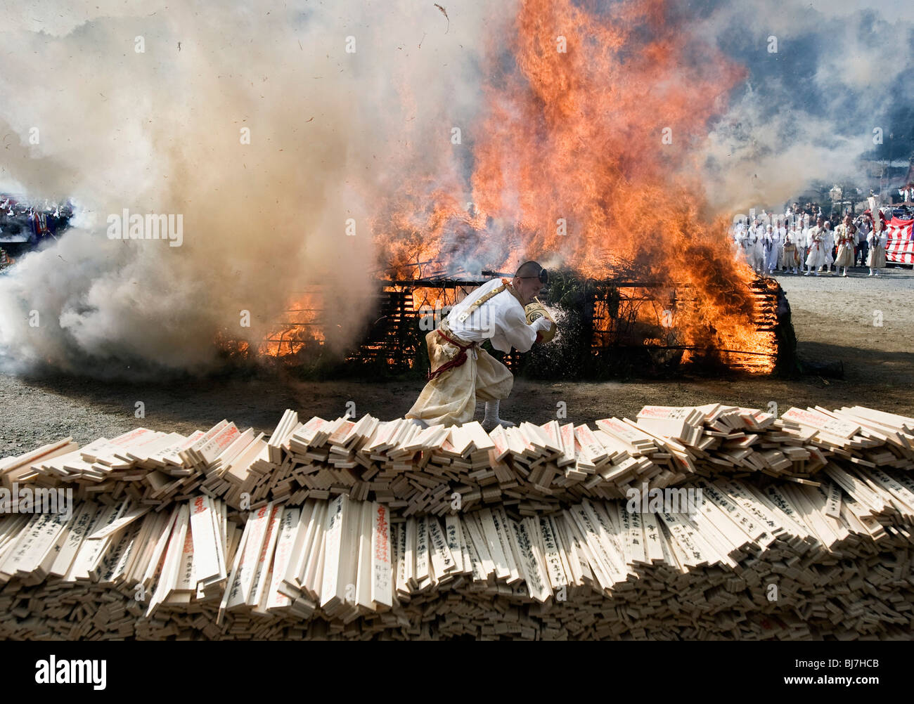 A Buddhist priest douses with buckets of water the flames of a fire ...