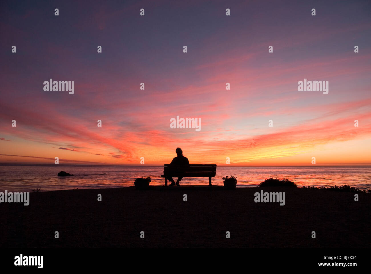 Man on bench during a California sunset Stock Photo - Alamy