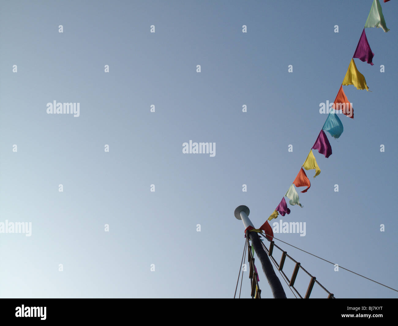 Coloured flags strung from a ship's mast against a blue sky Stock Photo ...