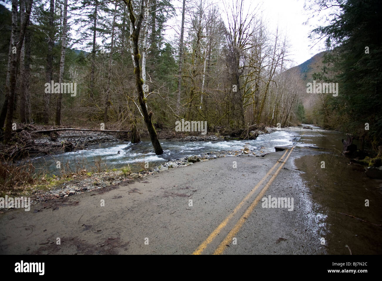 Flooded river changes path onto roadway in index, washington Stock ...
