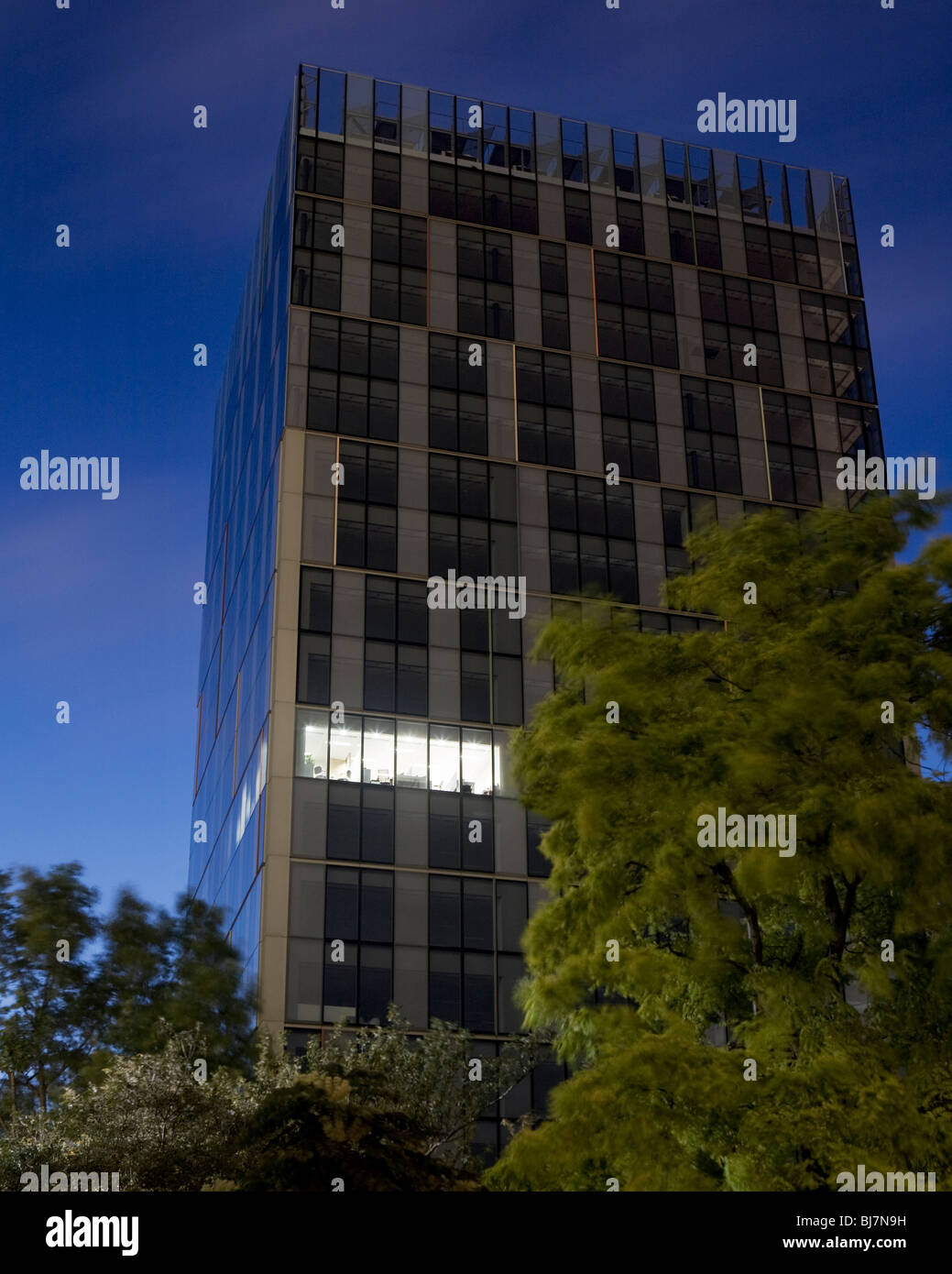 Office block at night with one room lit up Stock Photo - Alamy