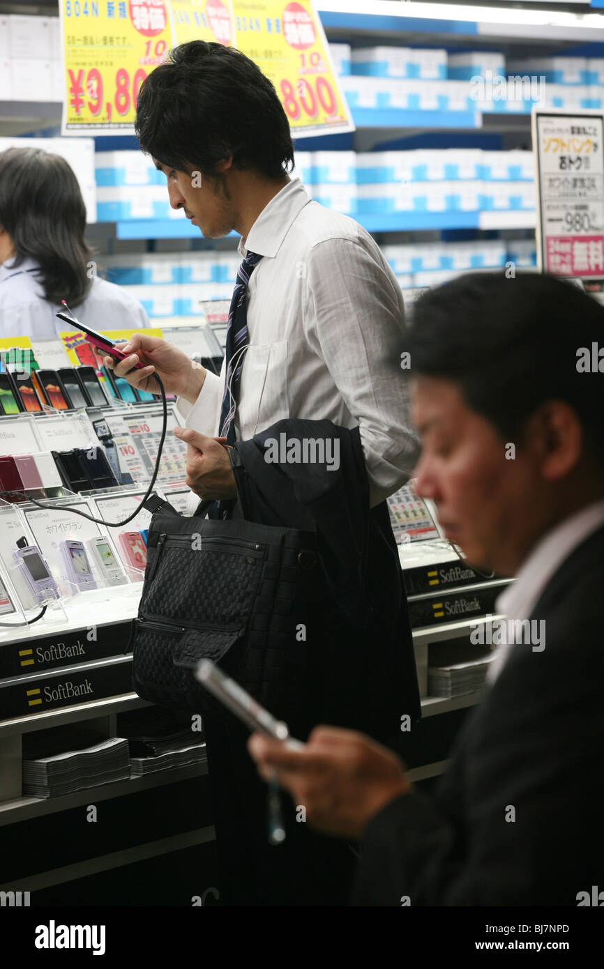 Customers shopping for new mobile telephones in phone store in Tokyo ...