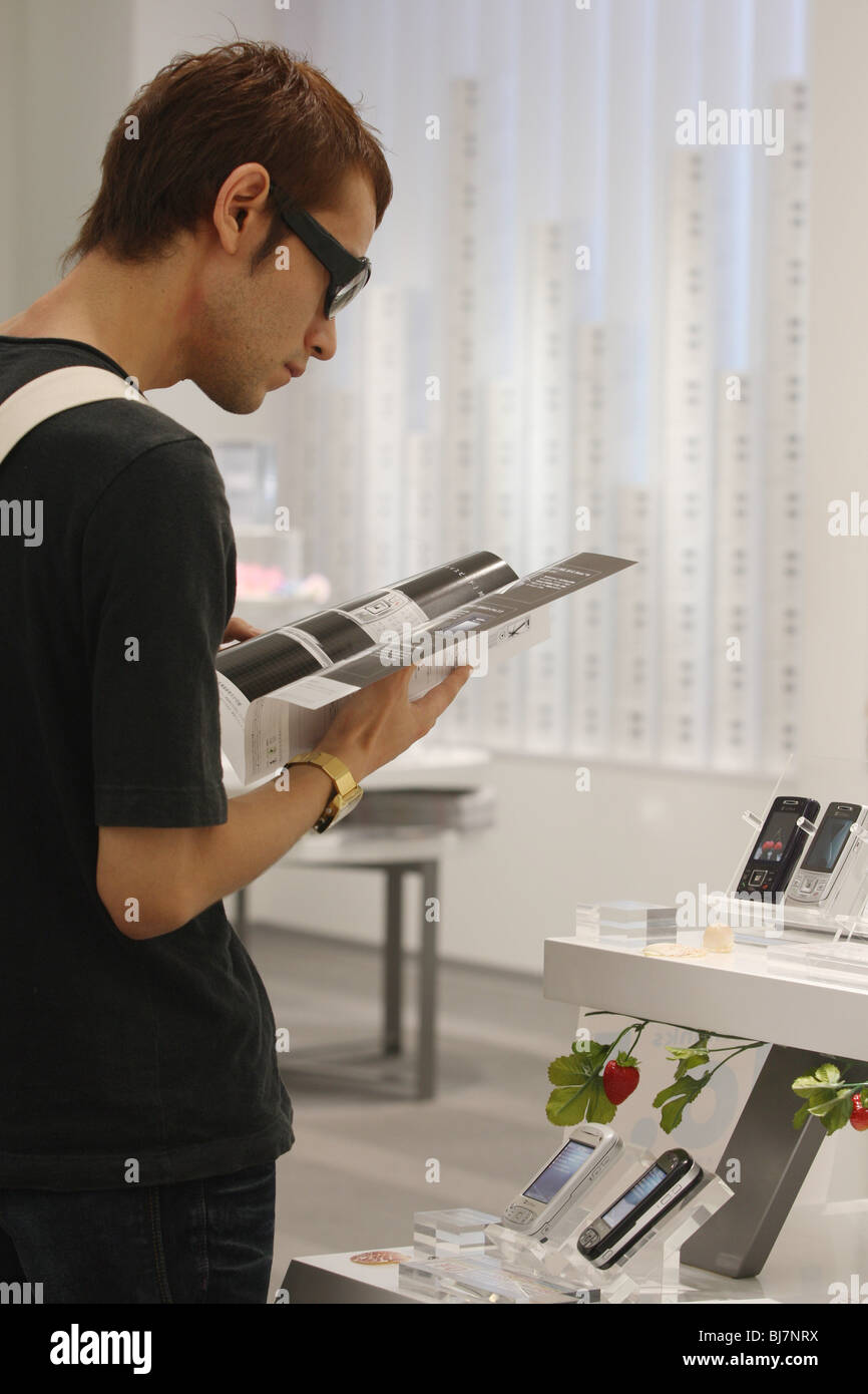 Customers shopping for new mobile telephones in phone store in Tokyo ...