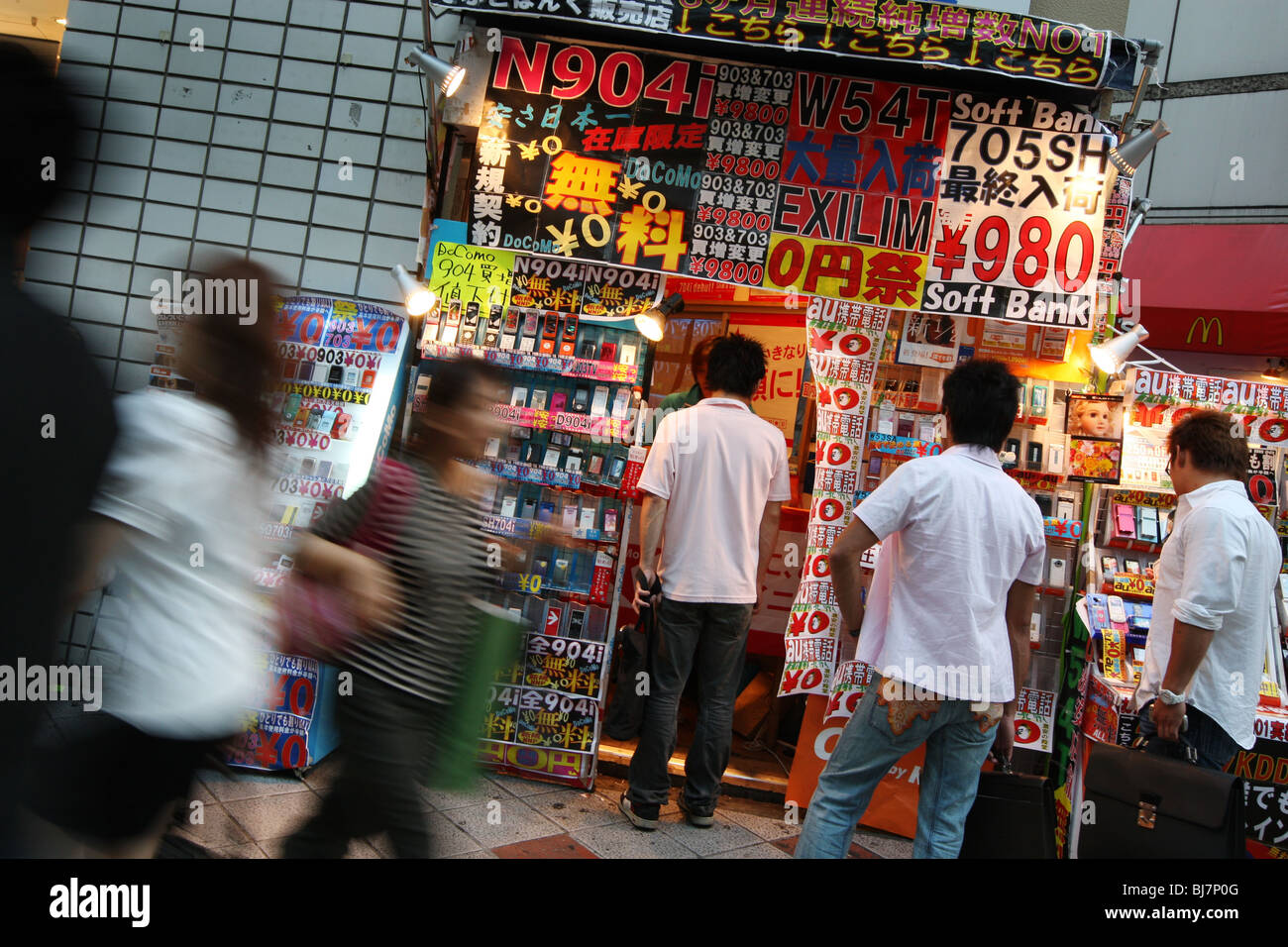Customers shopping for new mobile telephones in phone store in Tokyo ...