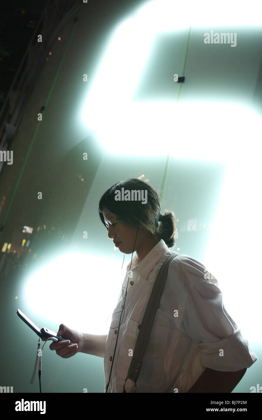 Japanese people using mobile telephone in front of digital number ...