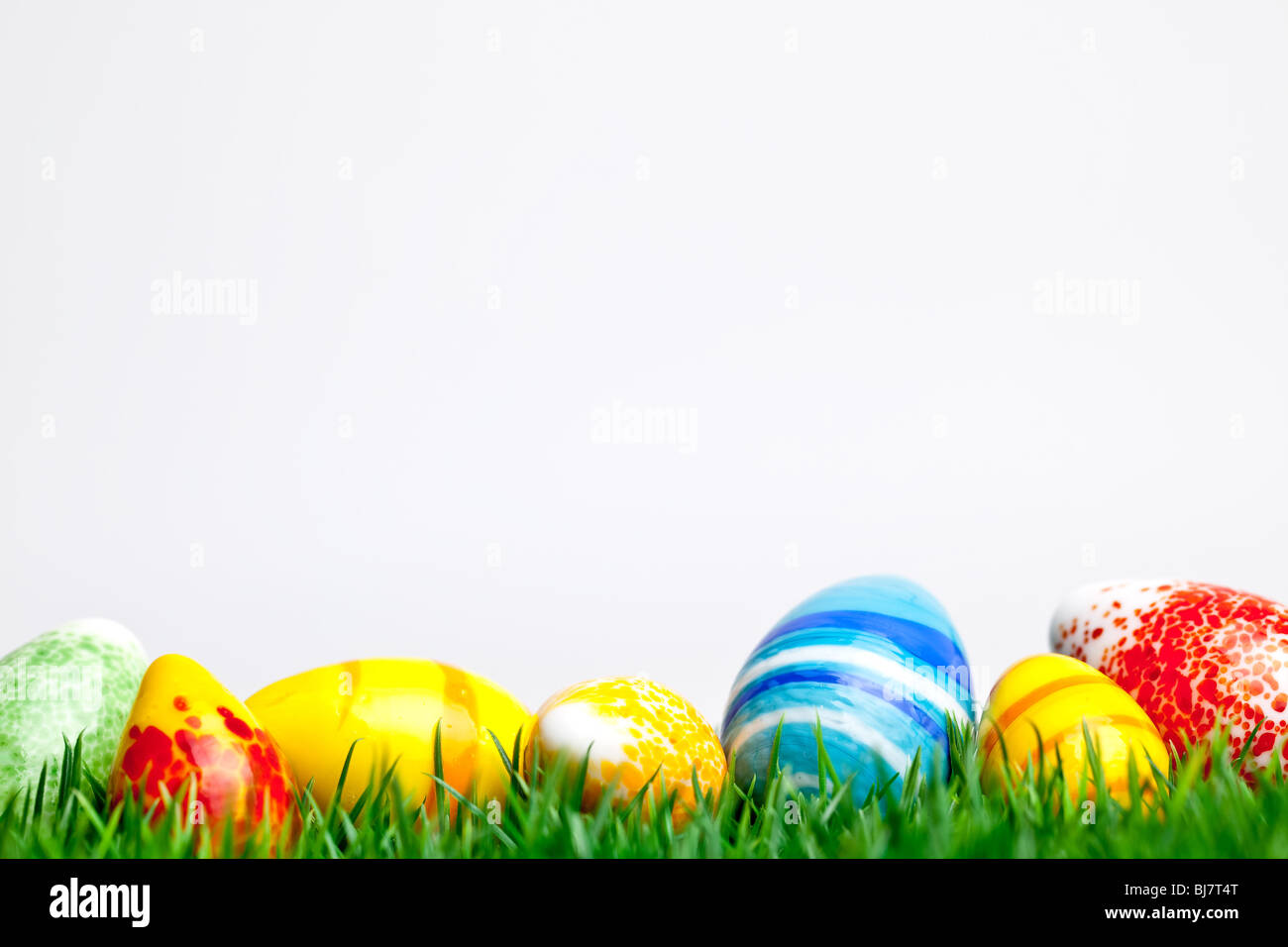 Easter eggs in green grass isolated on white background Stock Photo - Alamy