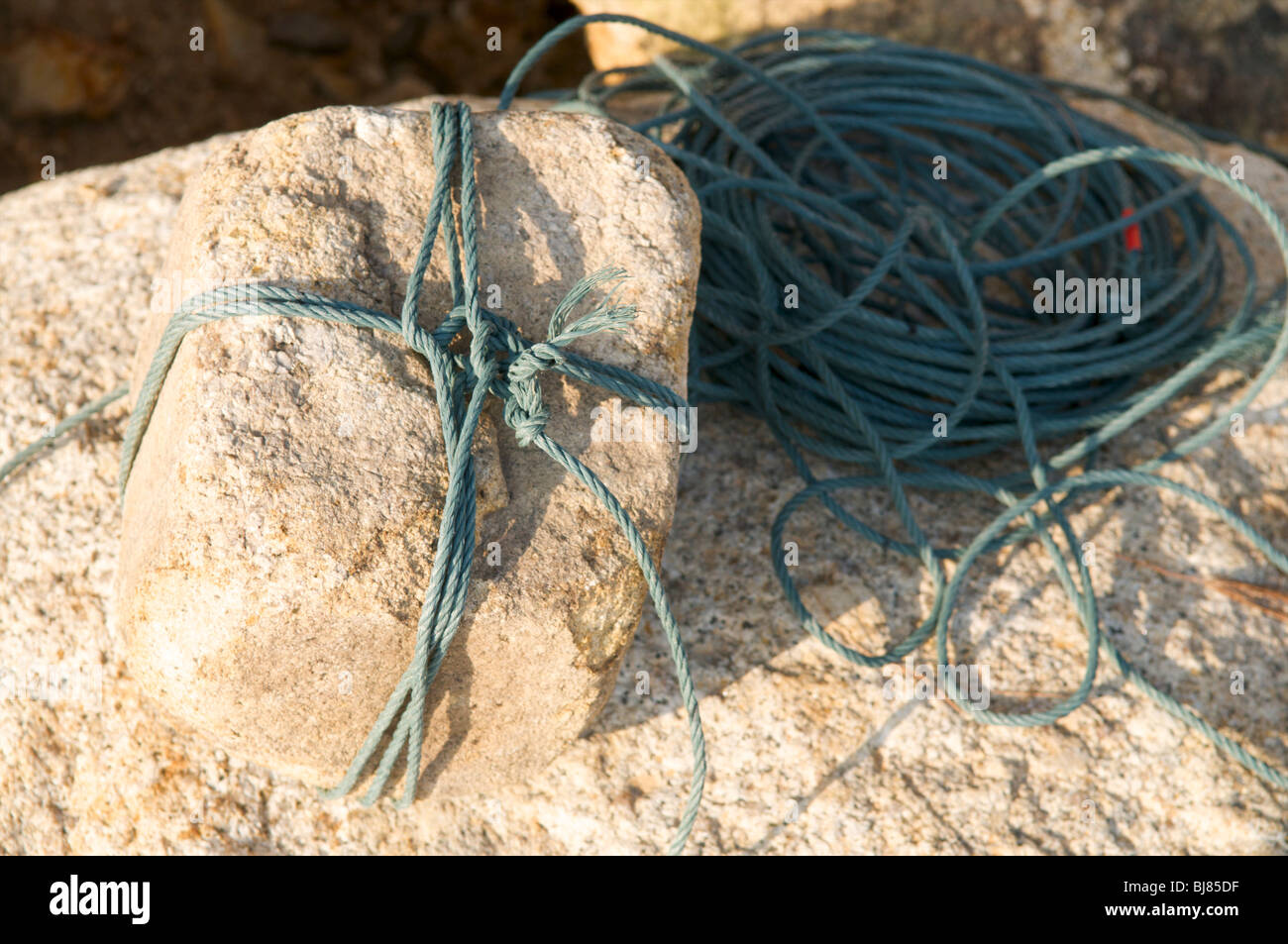 Rope tied around a rock Stock Photo - Alamy