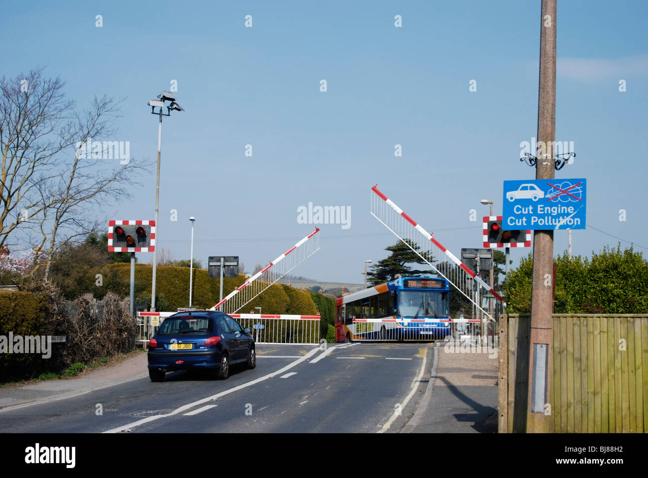 traffic at a railway level crossing with the barriers coming down Stock ...