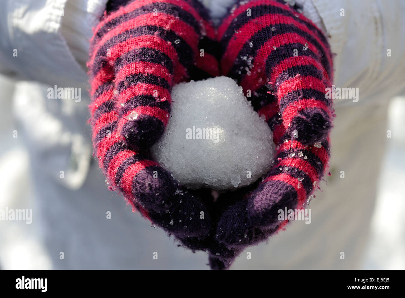 Child holding snowball in gloved hands. FULLY MODEL RELEASED Stock ...