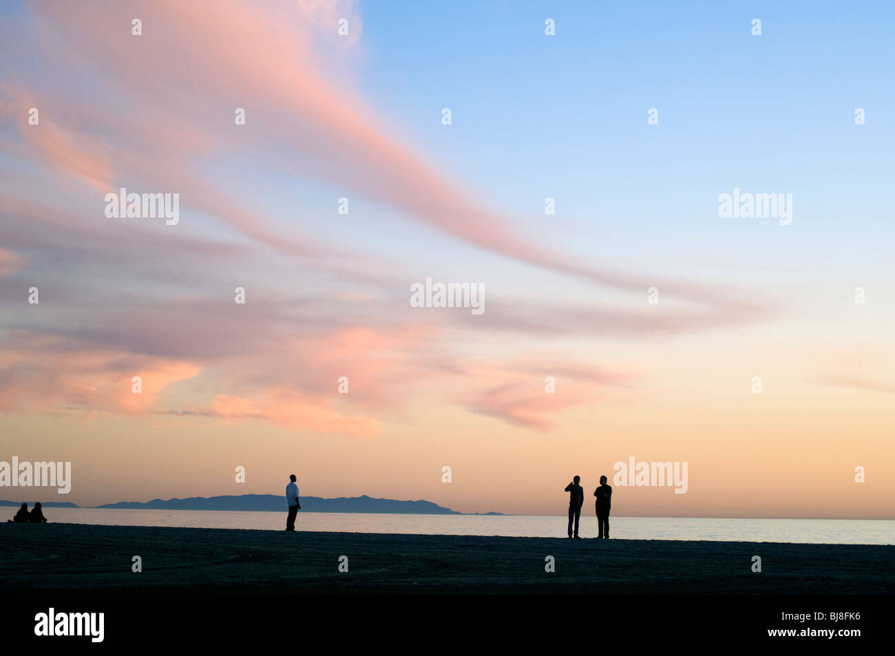 People on beach at sunset Stock Photo - Alamy