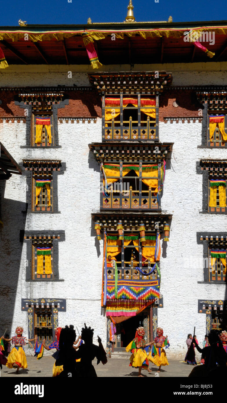 Dancers in bright yellow clothes dance at the Trashigang festival ...