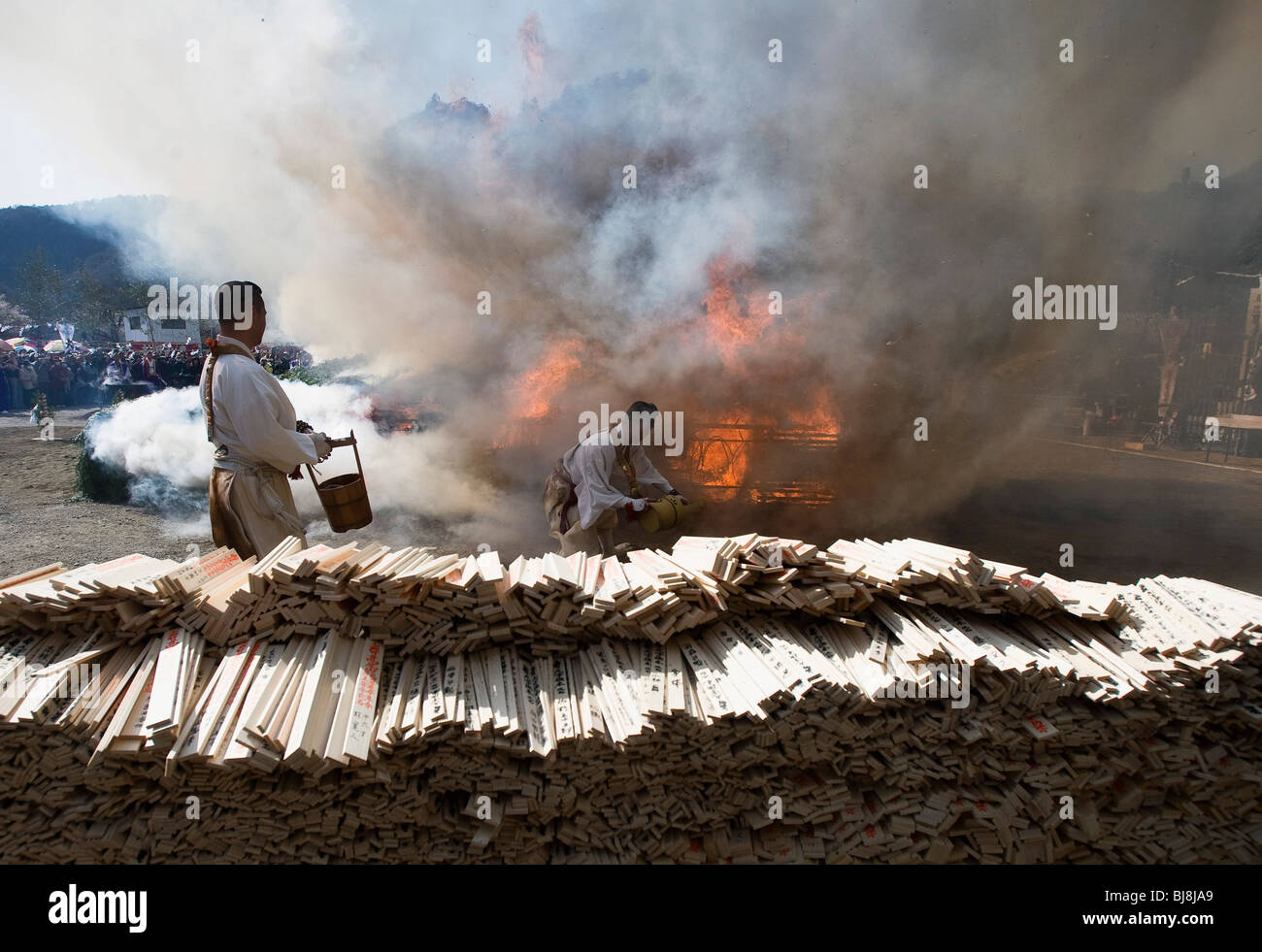 A Buddhist priest douses the flames of a fire used in a purification ...