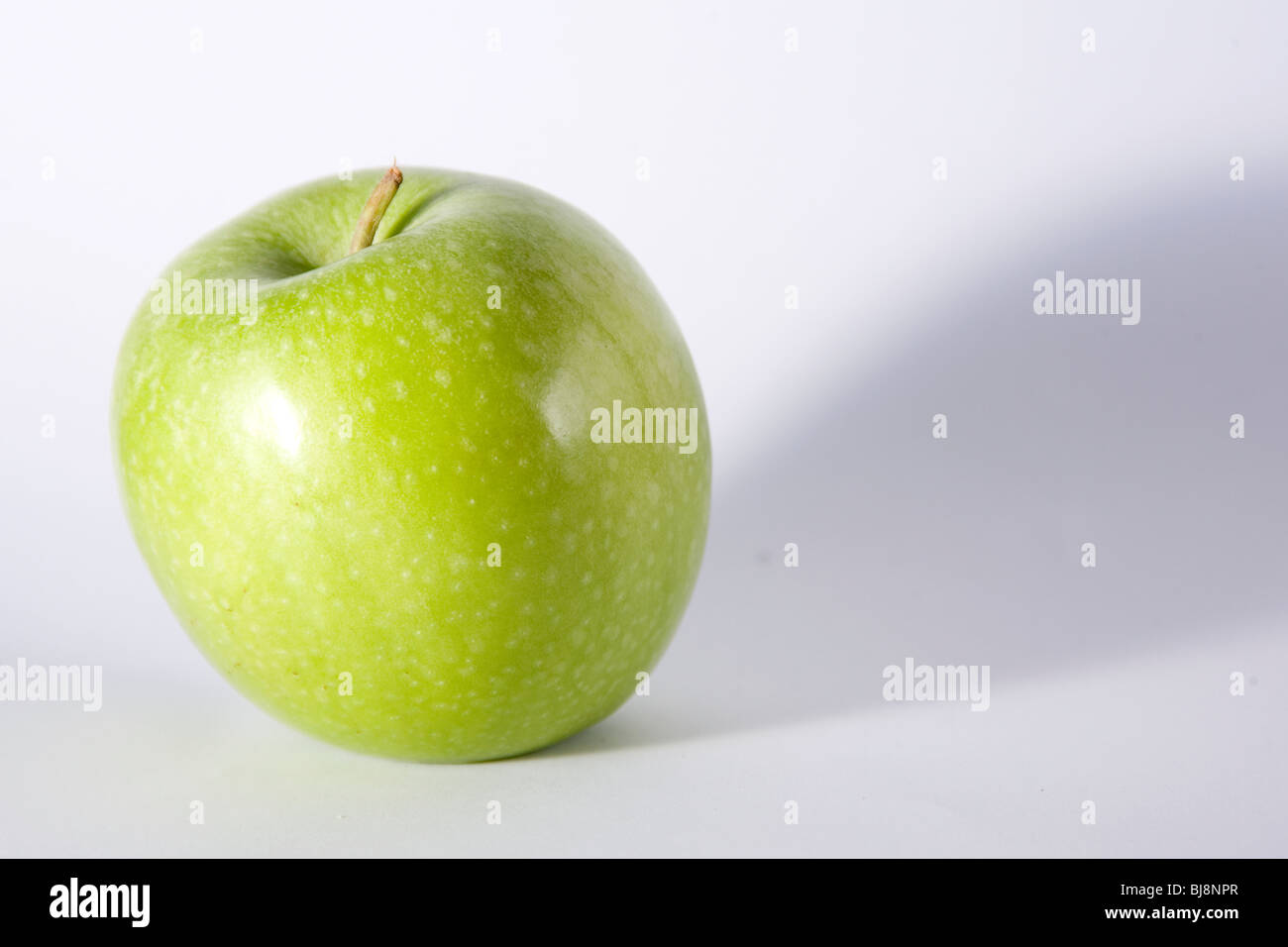 A green apple on white background with drop shadow Stock Photo - Alamy