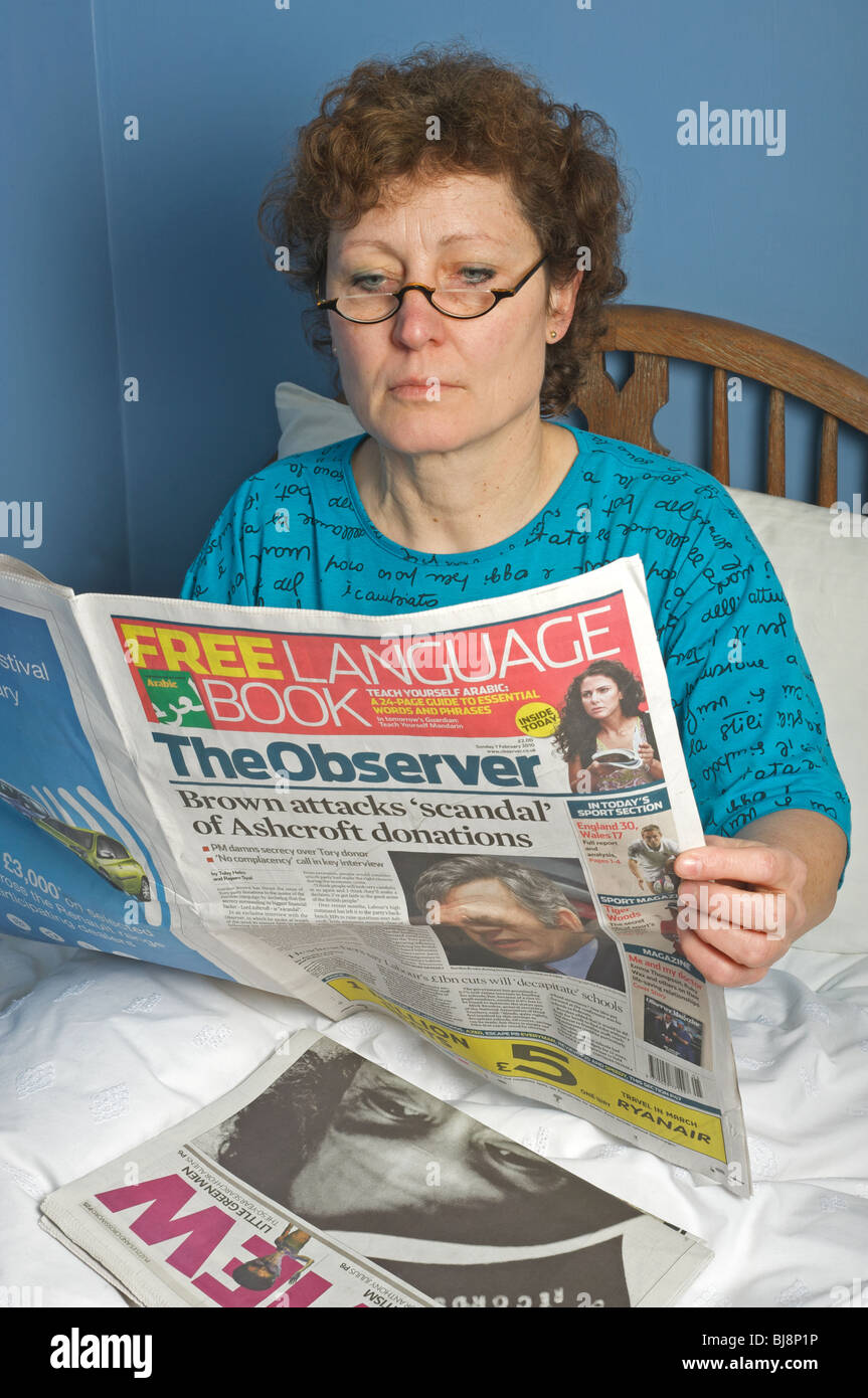 Woman relaxing reading broadsheet newspaper hi-res stock photography ...