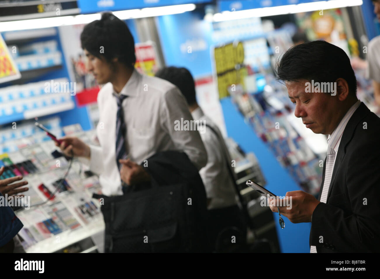 Customers shopping for new mobile telephones in phone store in Tokyo ...
