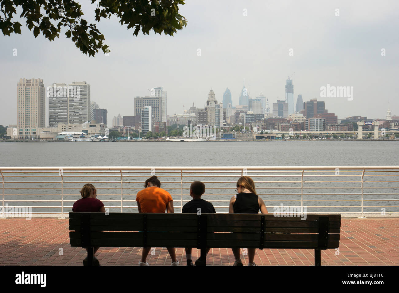 Teenagers on a bench watching the skyline of Philadelphia, USA Stock ...