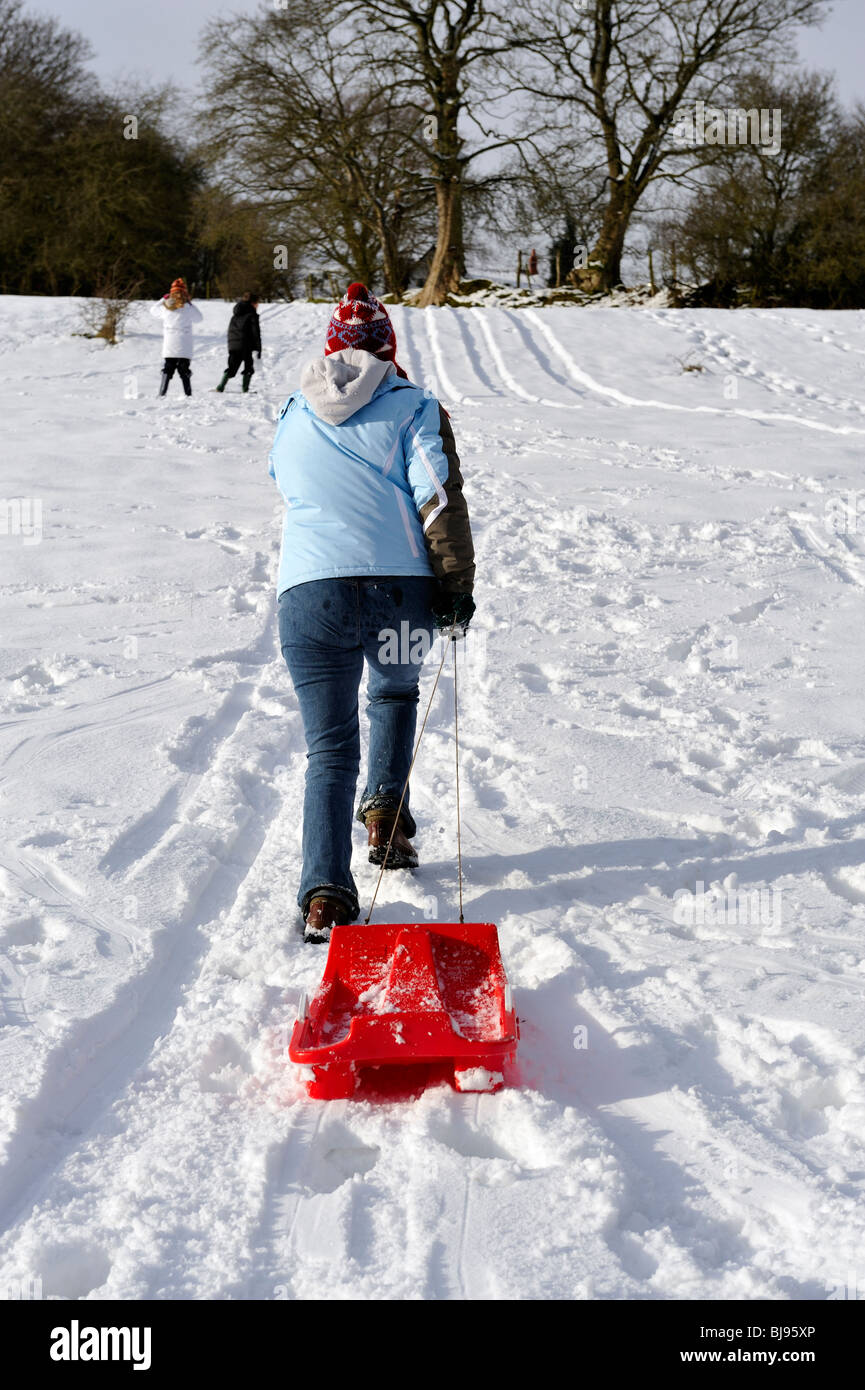 Mother and children climb Snow covered hill with sledge at Loggerheads ...