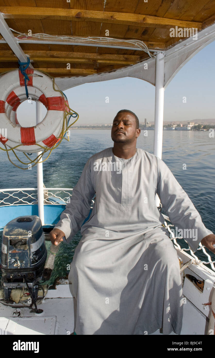 River boatman at the tiller on the Nile River near Aswan, Egypt, Africa ...