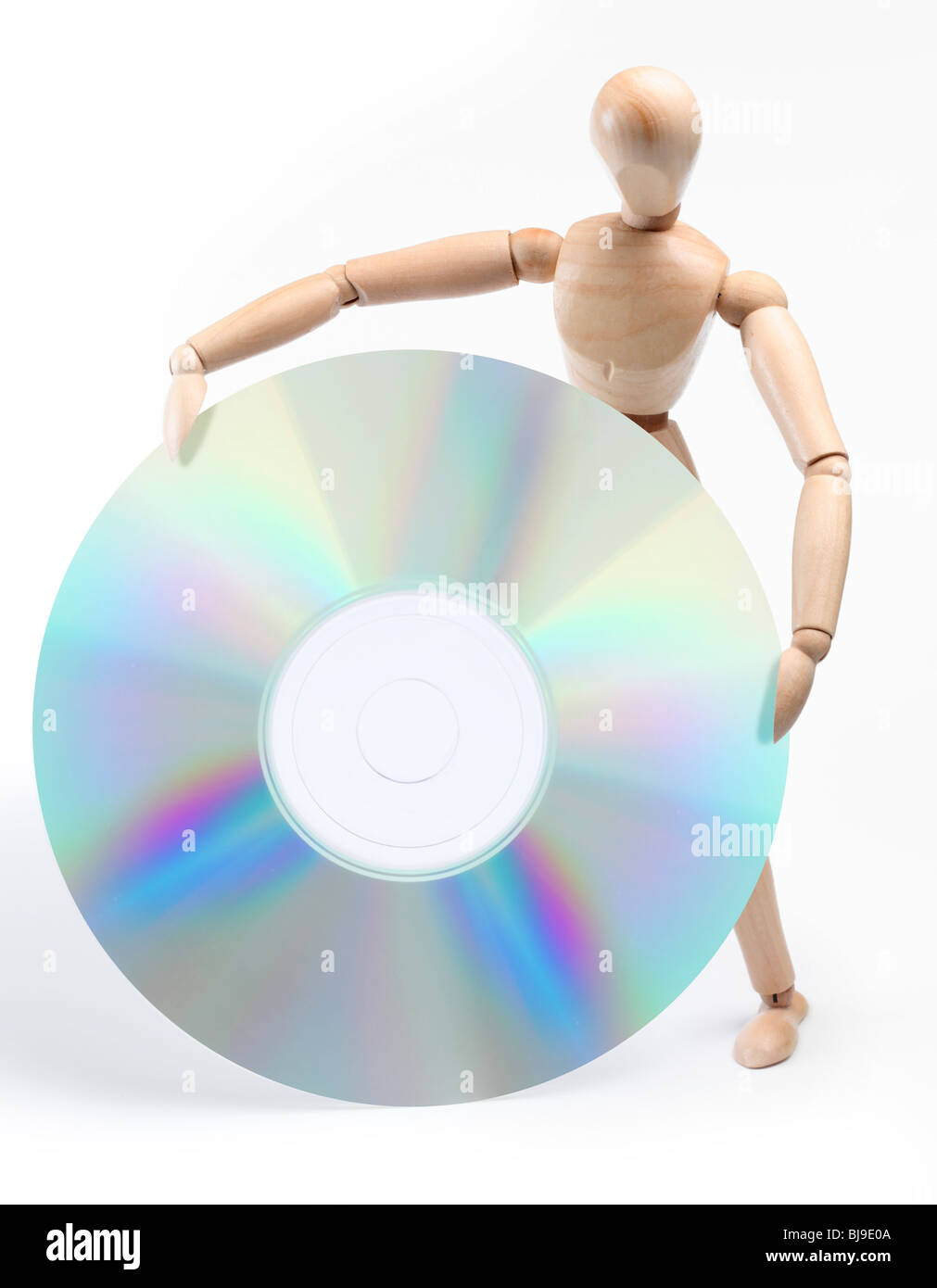 Wooden man holding a large computer disc. Isolated over white Stock ...