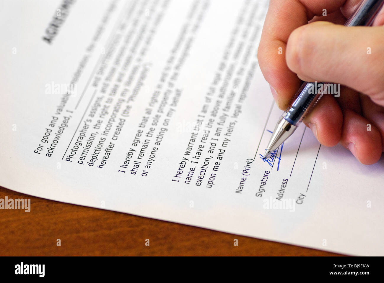 Male hand signing a document Stock Photo - Alamy