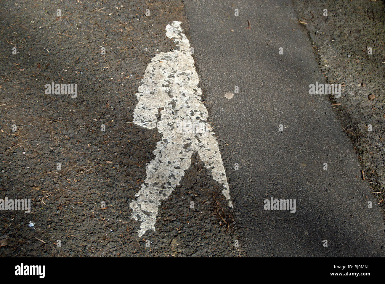 british road marking using image of man, partially concealed by new ...